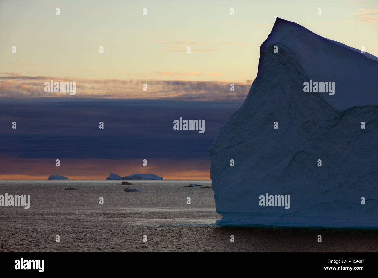 Huge icebergs on very calm sea with sunset sky in Disko Bay in the ...