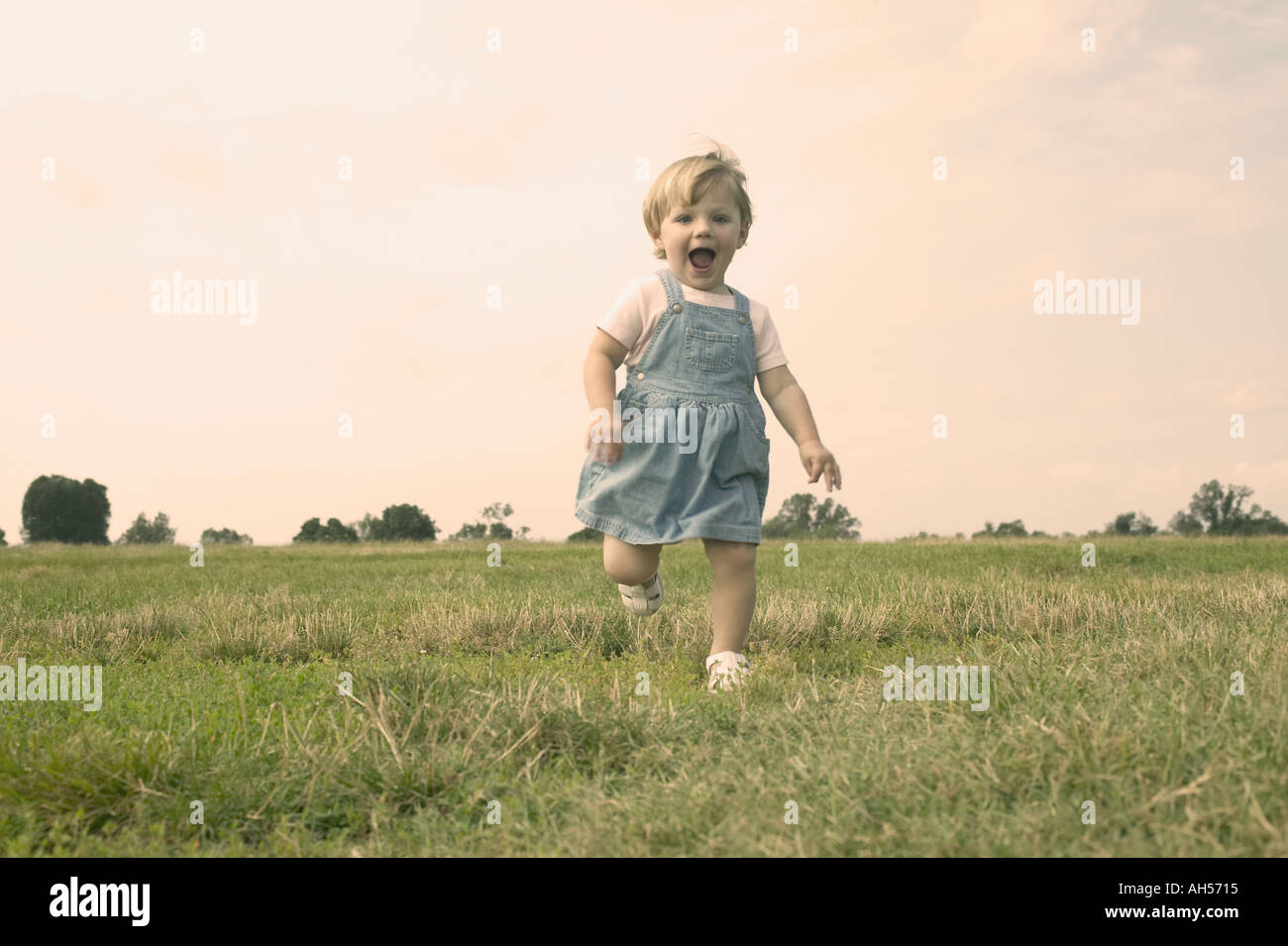 Young Girl Running in Open Field Stock Photo - Alamy