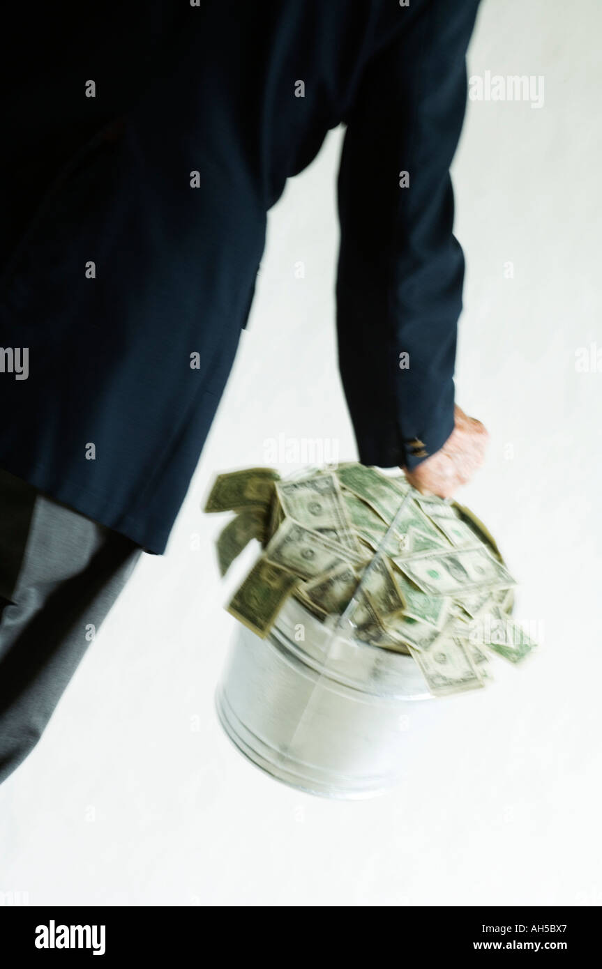 business man carrying bucket of dollar bills US Stock Photo - Alamy