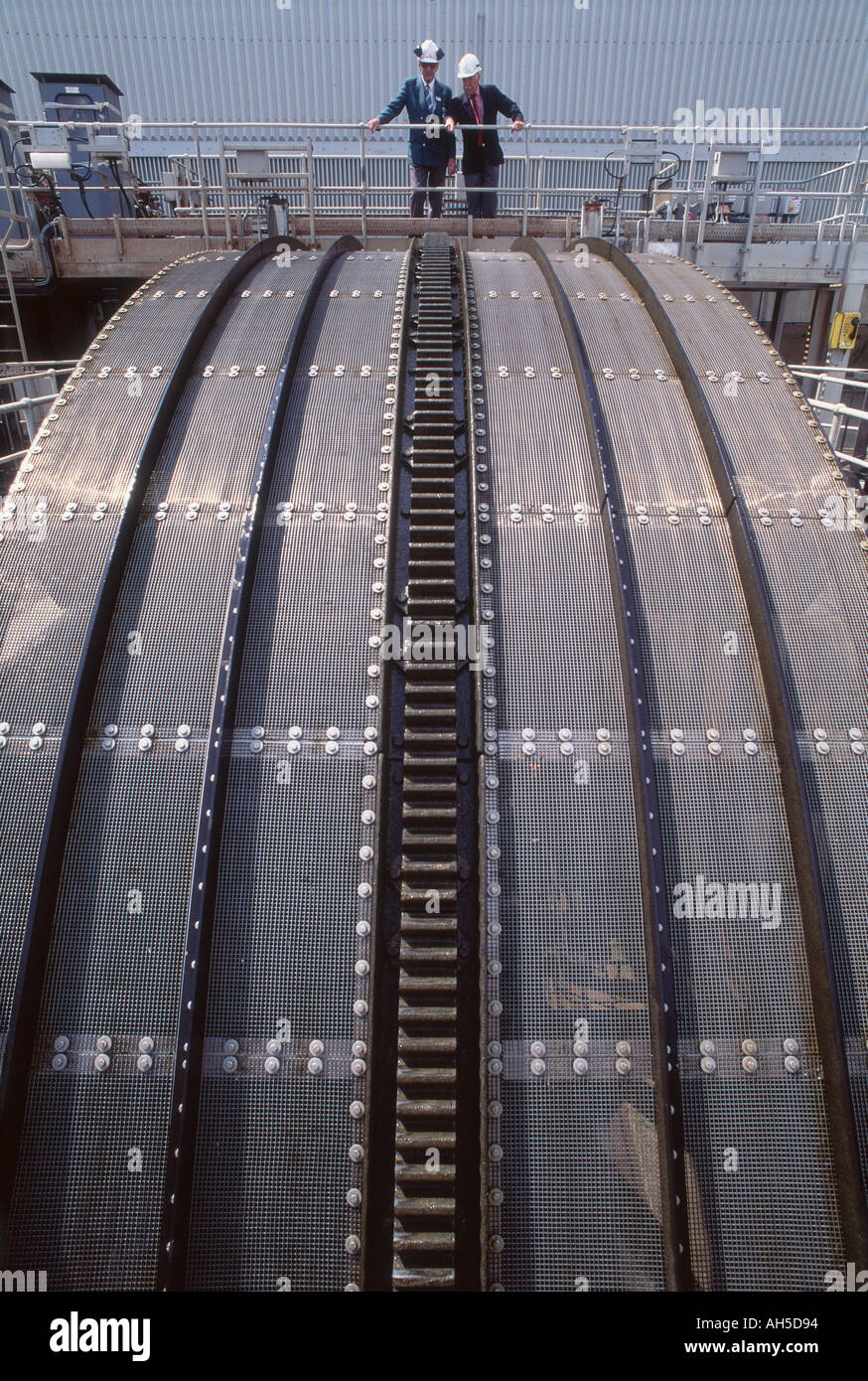 Two engineers inspecting large drum screen which clean seawater intake ...