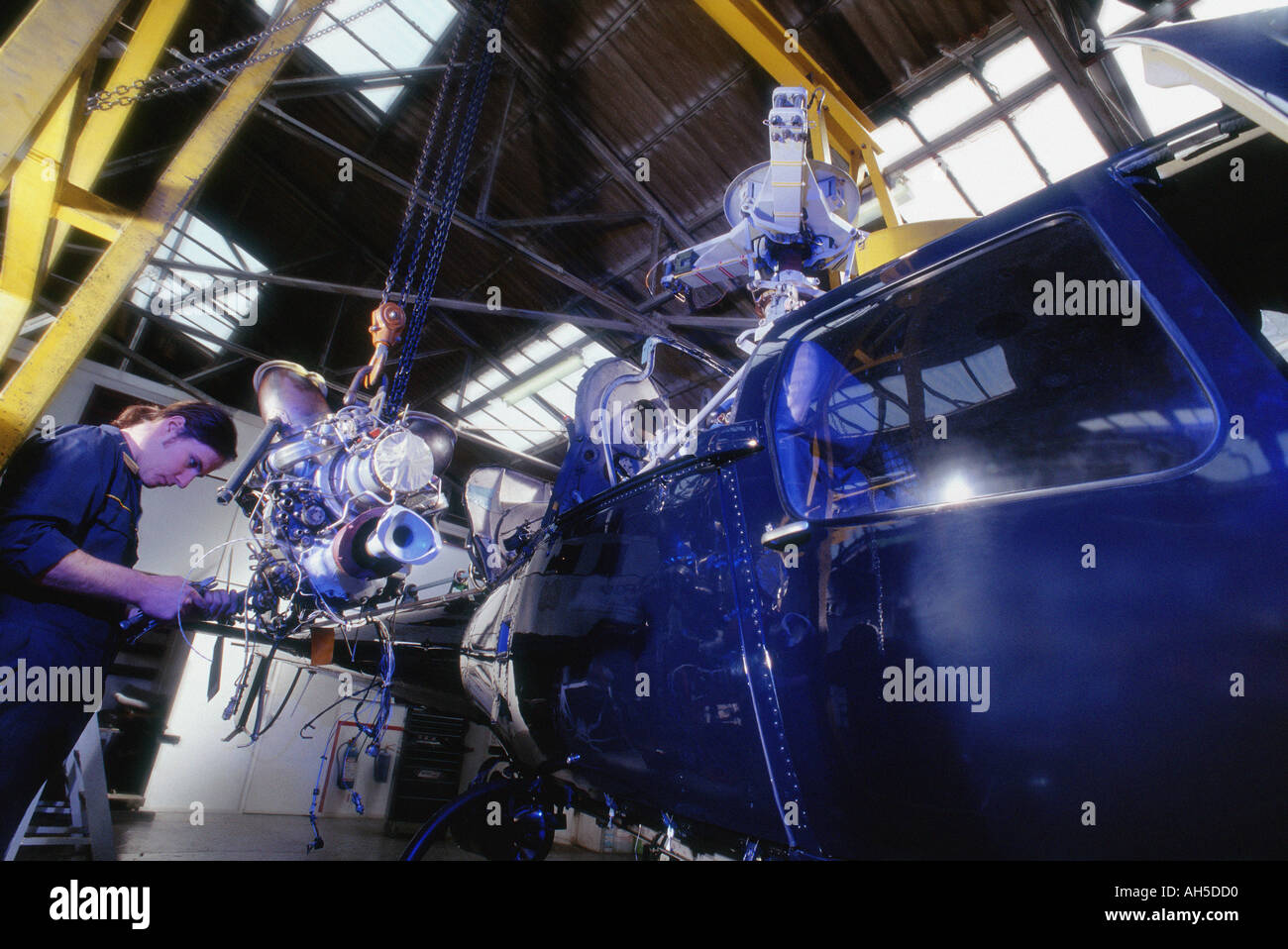 Aircraft hanger with mechanic working on helicopter engine Stock Photo ...