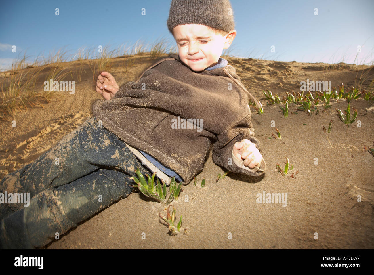 boy 6 laying and rolling in sand dunes Stock Photo - Alamy