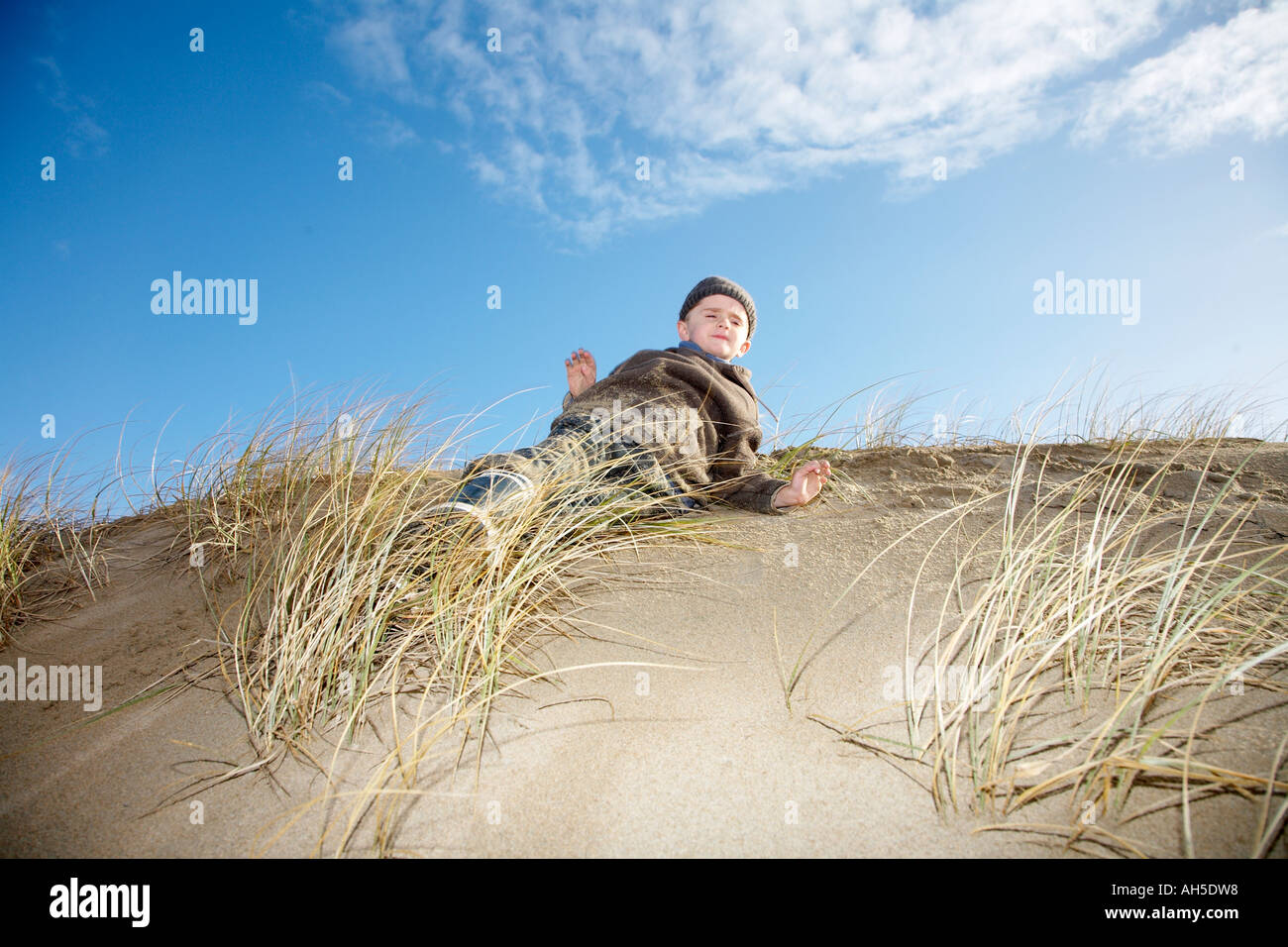 boy 6 laying and rolling in sand dunes Stock Photo - Alamy