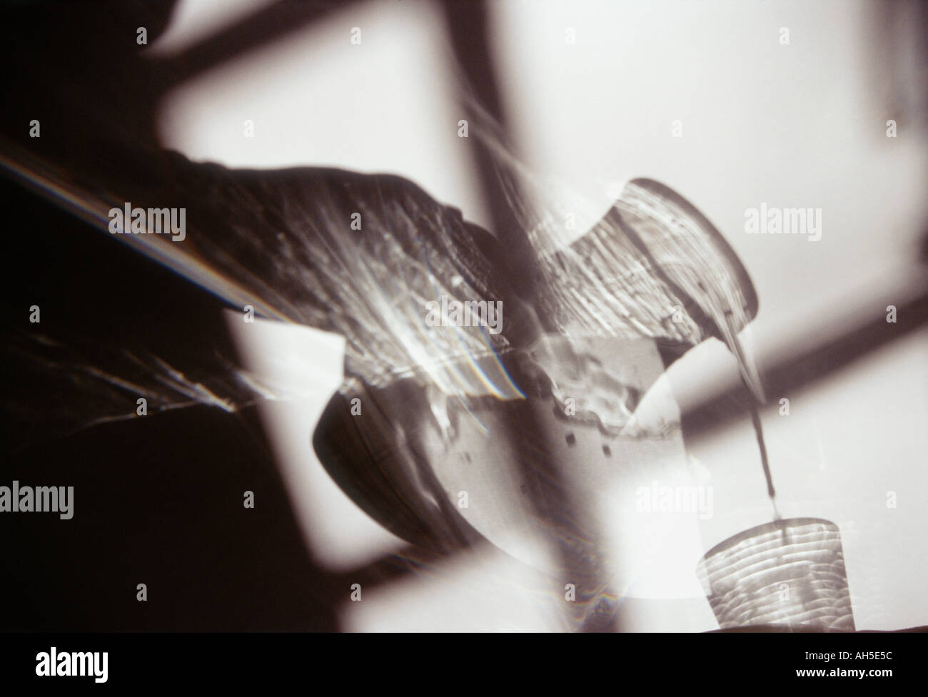 Reflection and shadow of hand holding jug and pouring water into a ...