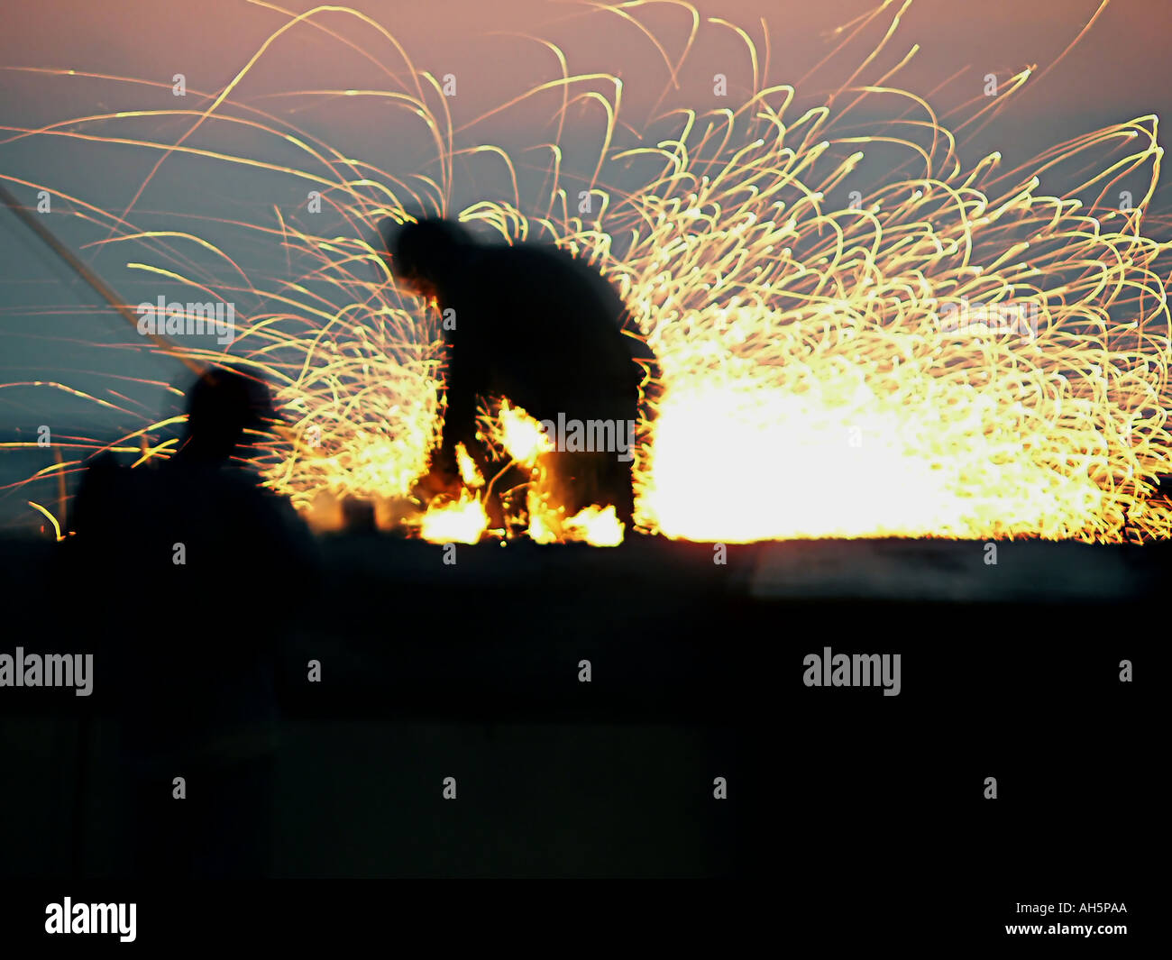 Man Welding at dusk Stock Photo - Alamy