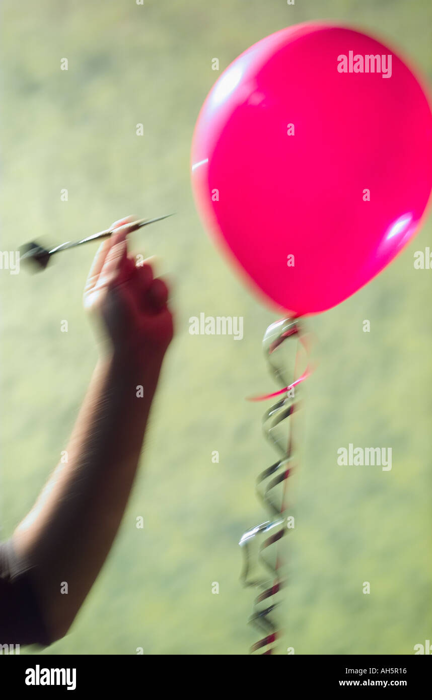 Hand Popping Party Balloon with Dart Stock Photo - Alamy
