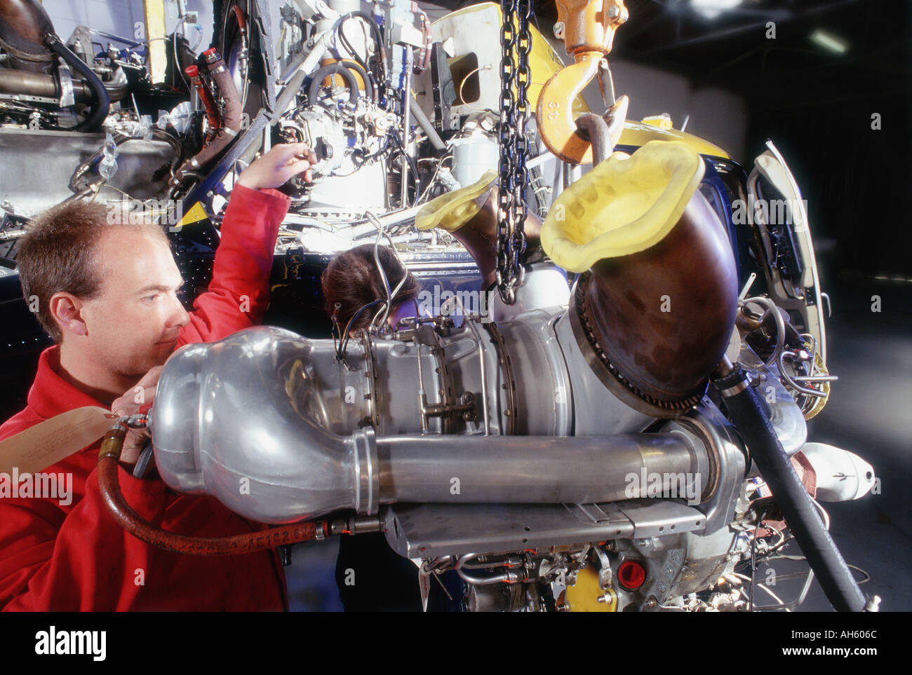 Aircraft engineer using hoist to move helicopter engine in hanger Stock ...