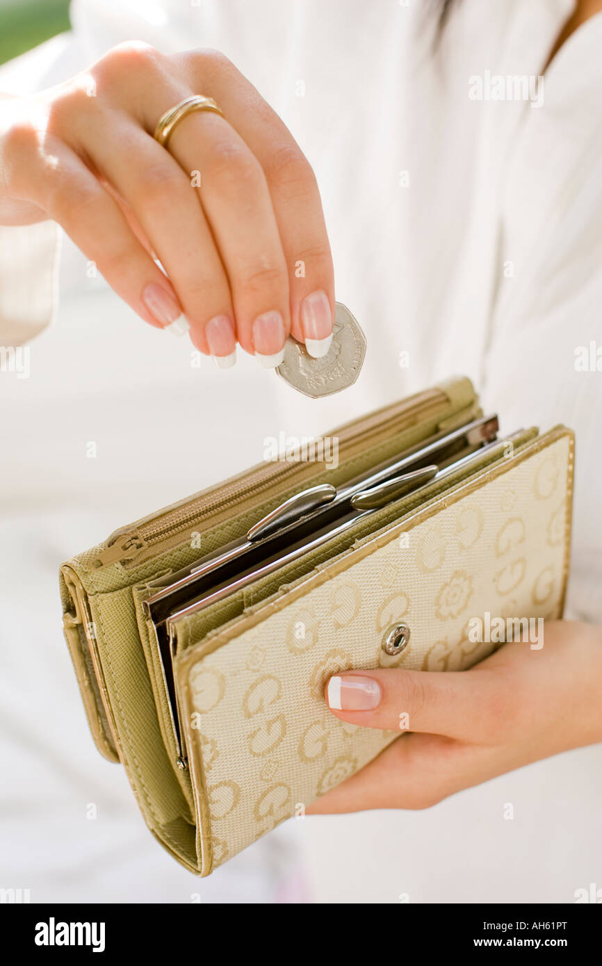 young woman putting coins in purse Stock Photo - Alamy