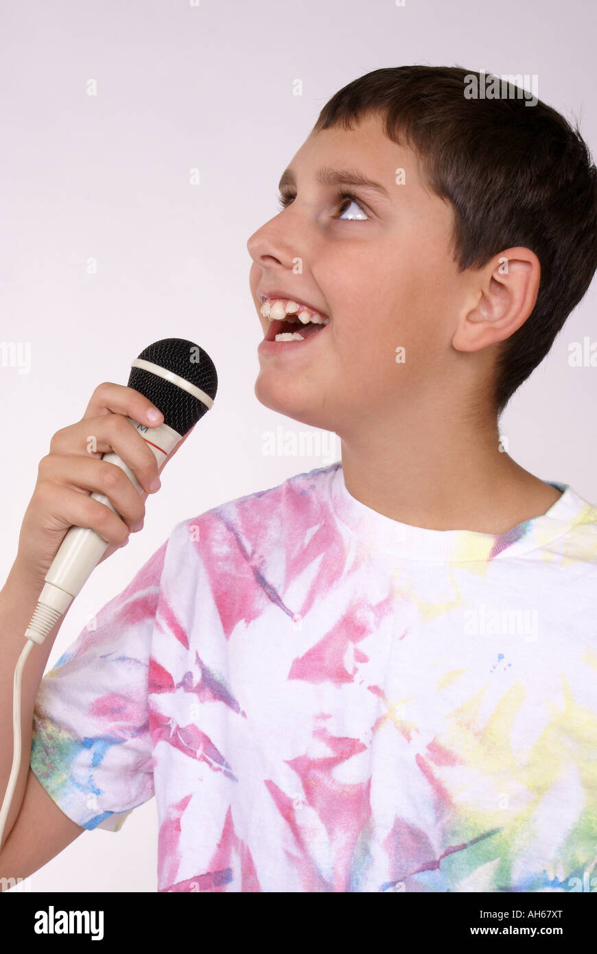 Young Boy Singing Into Microphone Stock Photo - Alamy
