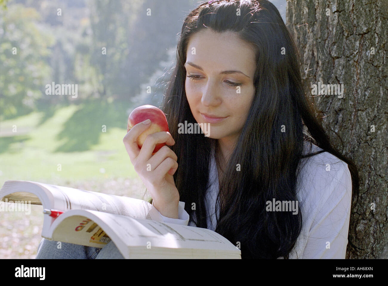 reading woman with apple sit under tree Stock Photo - Alamy