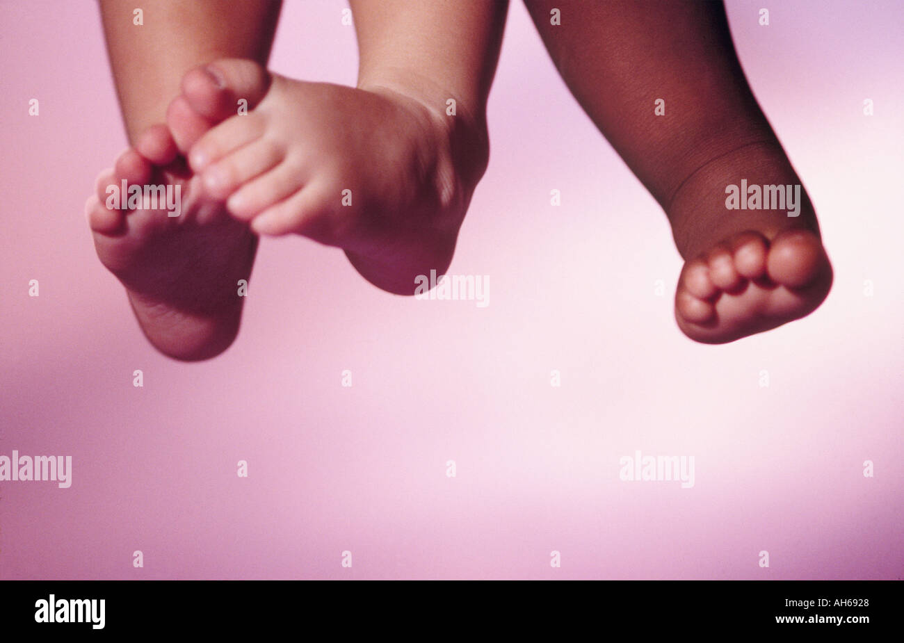 Three Baby feet Stock Photo - Alamy
