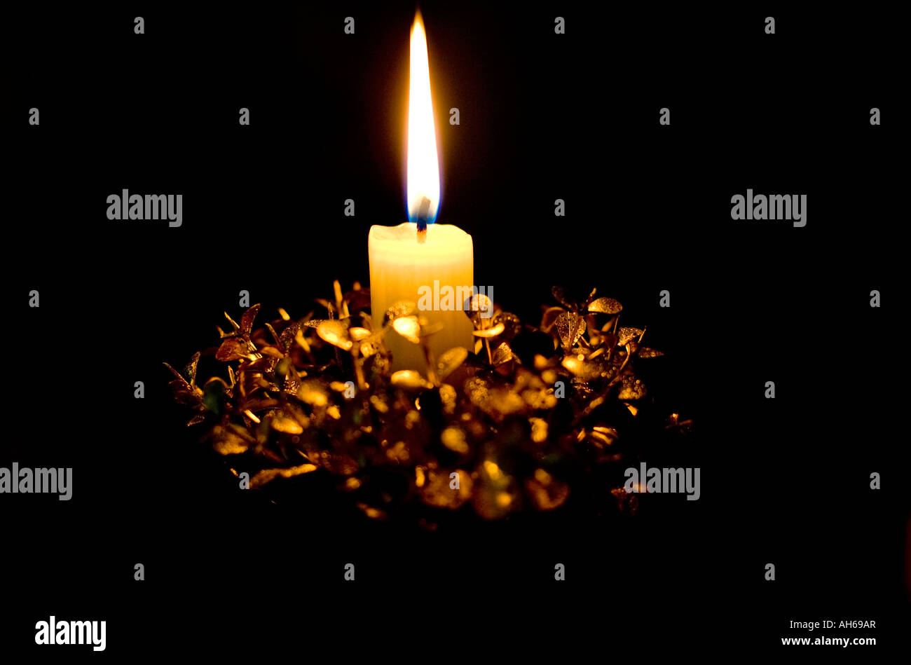 A lone candle throws a little light for guidance Stock Photo - Alamy