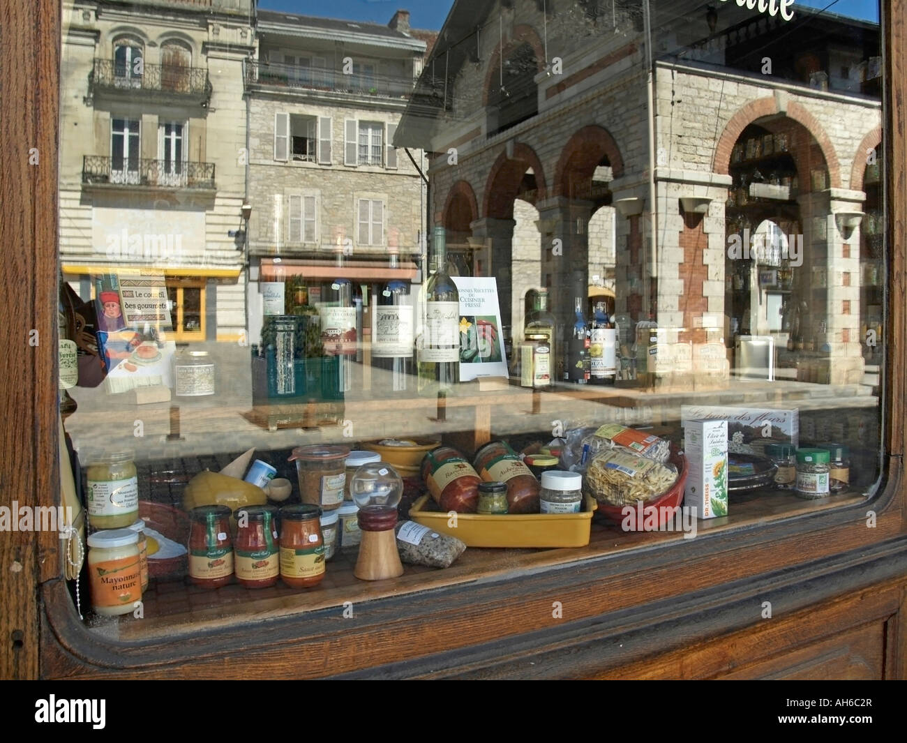 reflections of an old medieval town on shop window with delicatessen ...