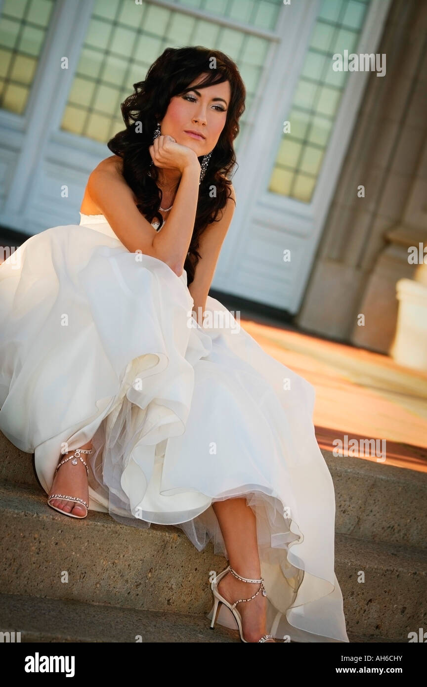 Bride sitting on steps and thinking Stock Photo - Alamy
