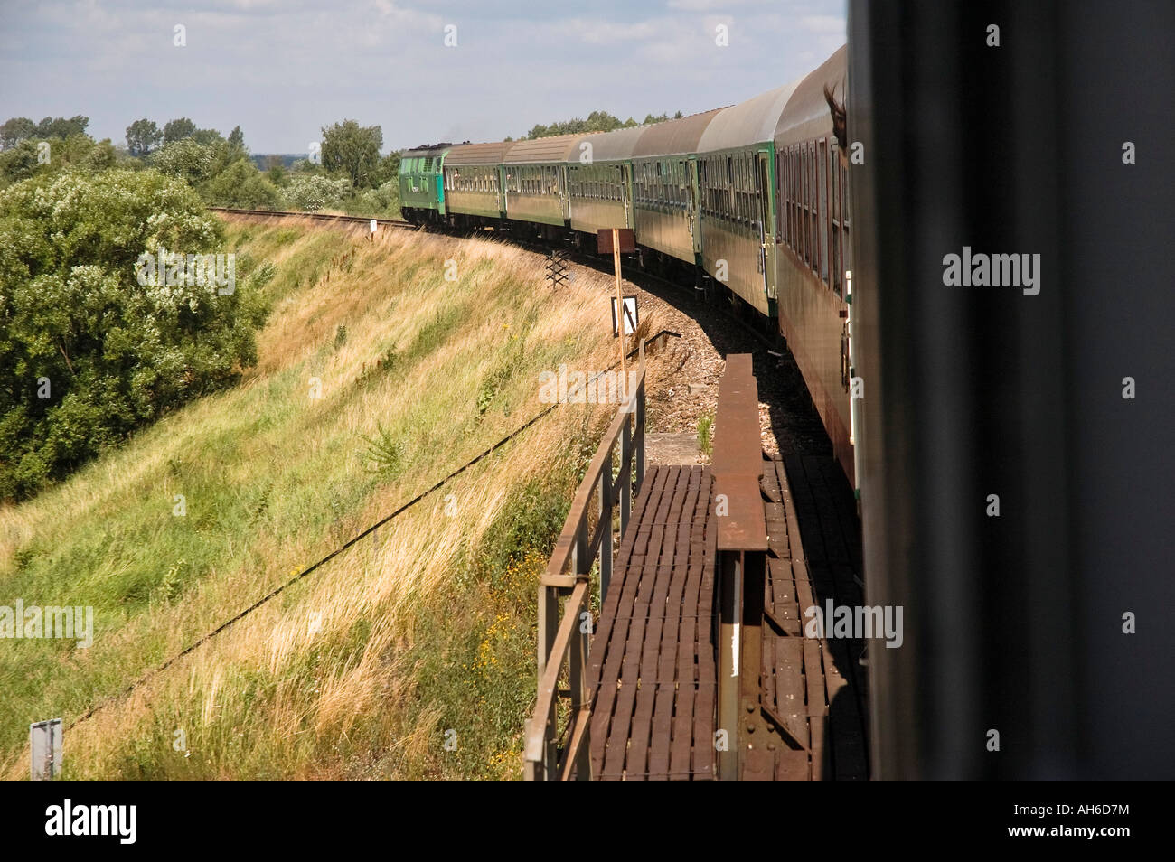Train running over small bridge on a bending track in eastern poland ...