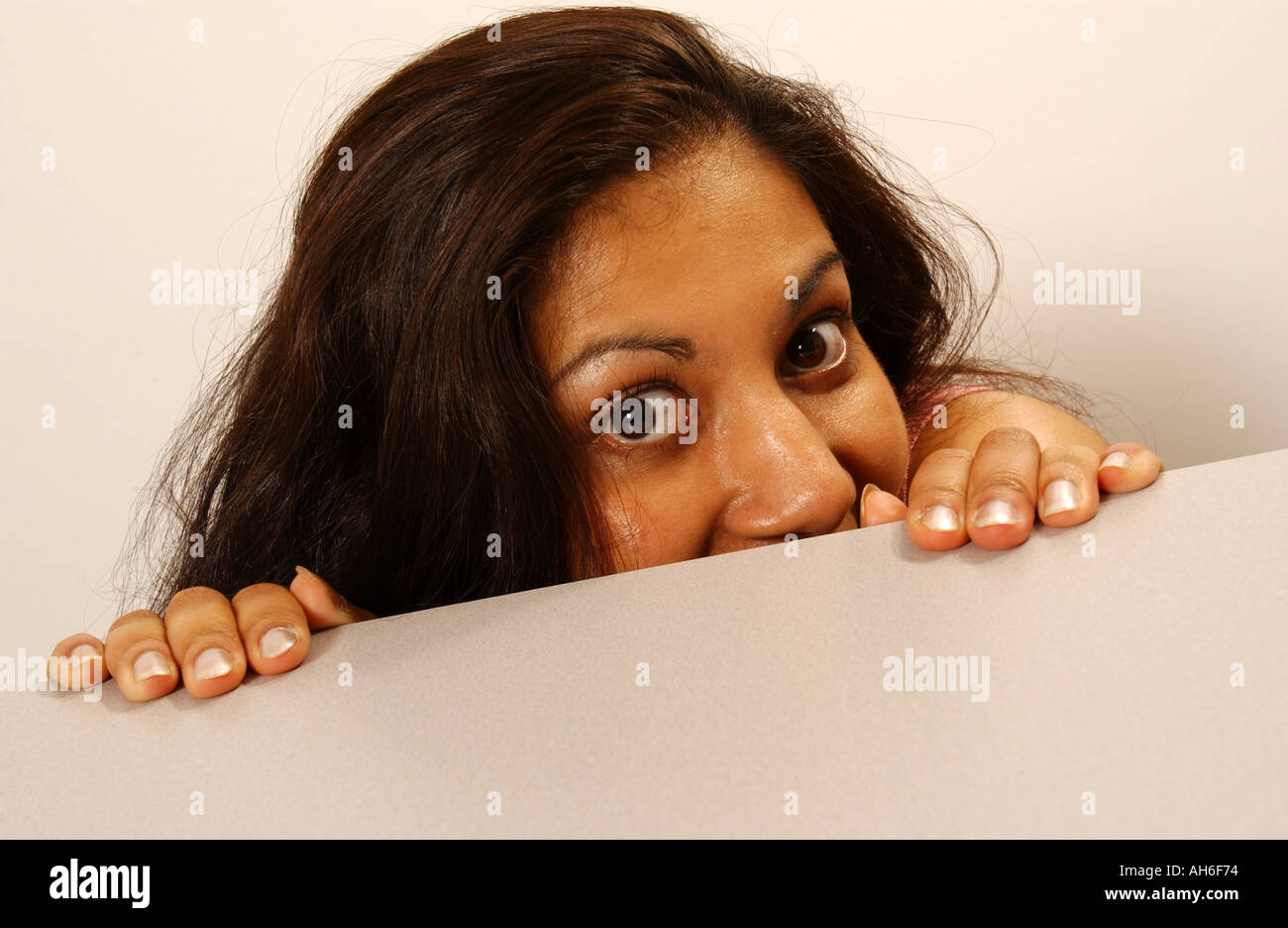 Young woman hiding behind table hi-res stock photography and images - Alamy