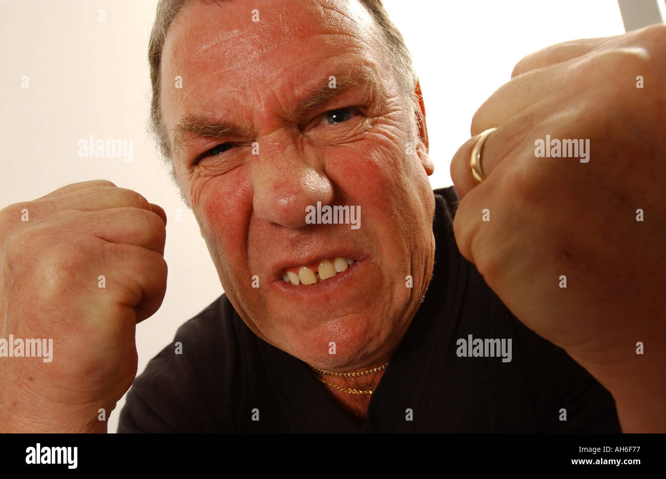 Angry man shaking his fists in fury and clenching his teeth Stock Photo ...