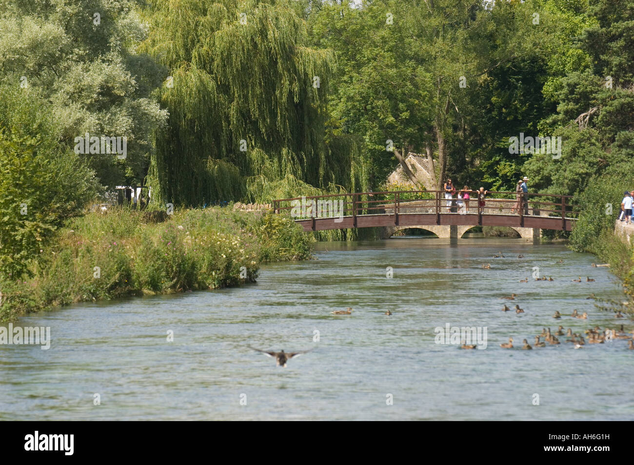 BIBURY GLOUCESTERSHIRE COTSWOLDS UK VISITORS AMIRING THE RIVER COLN ...