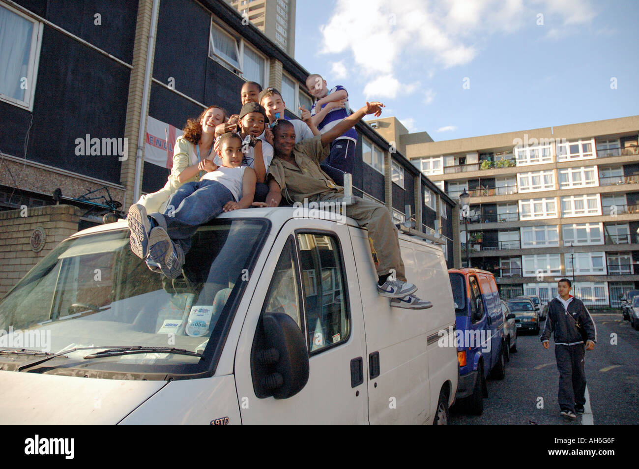 Lively group of children climbing and jumping on van parked on their ...