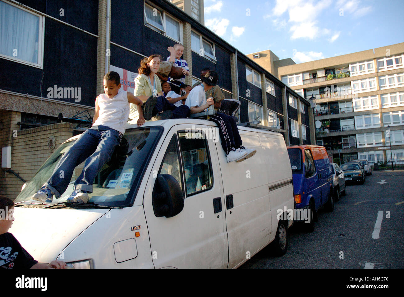 Lively group of children climbing and jumping on van parked on their ...