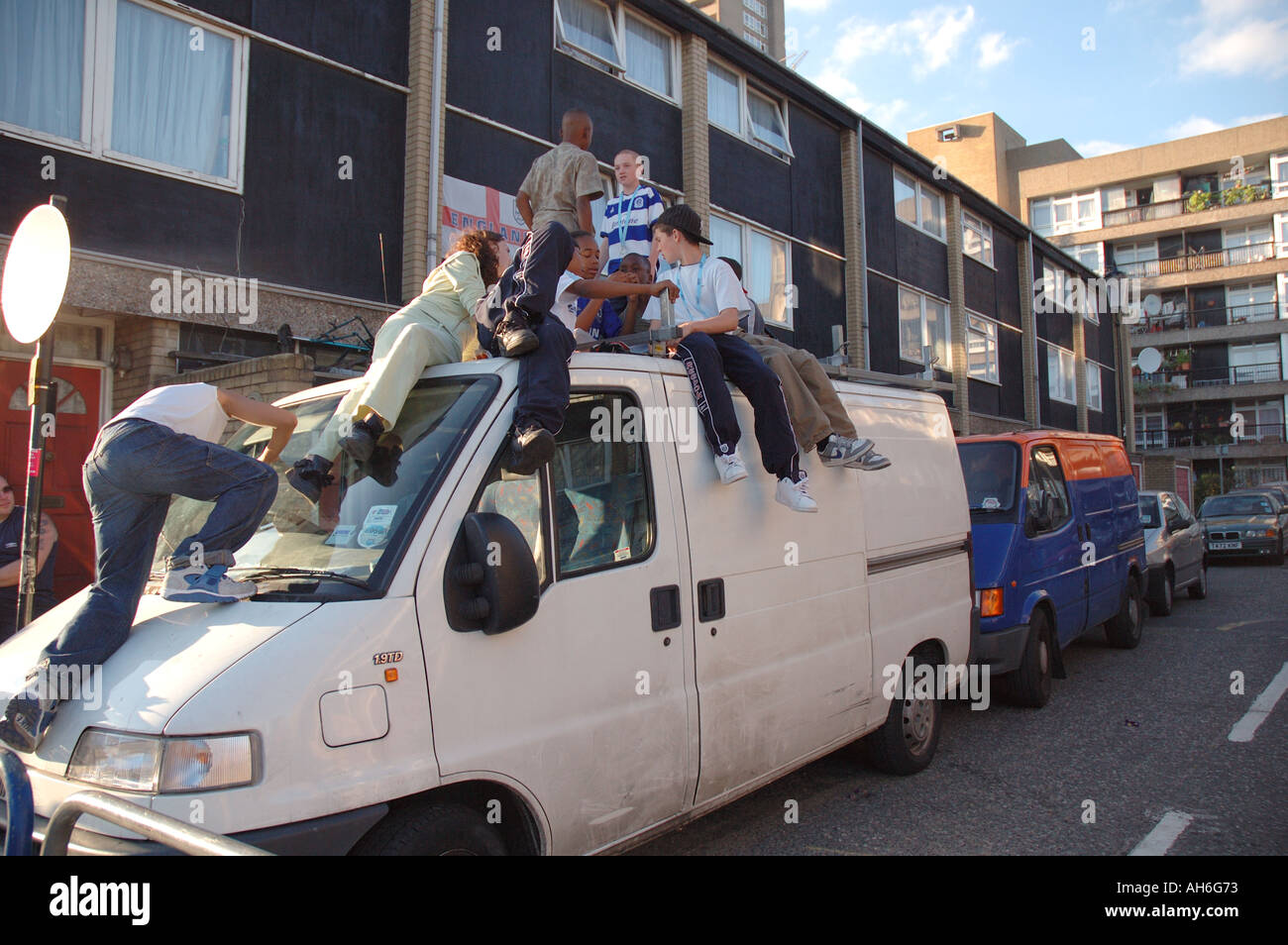Lively group of children climbing and jumping on van parked on their ...