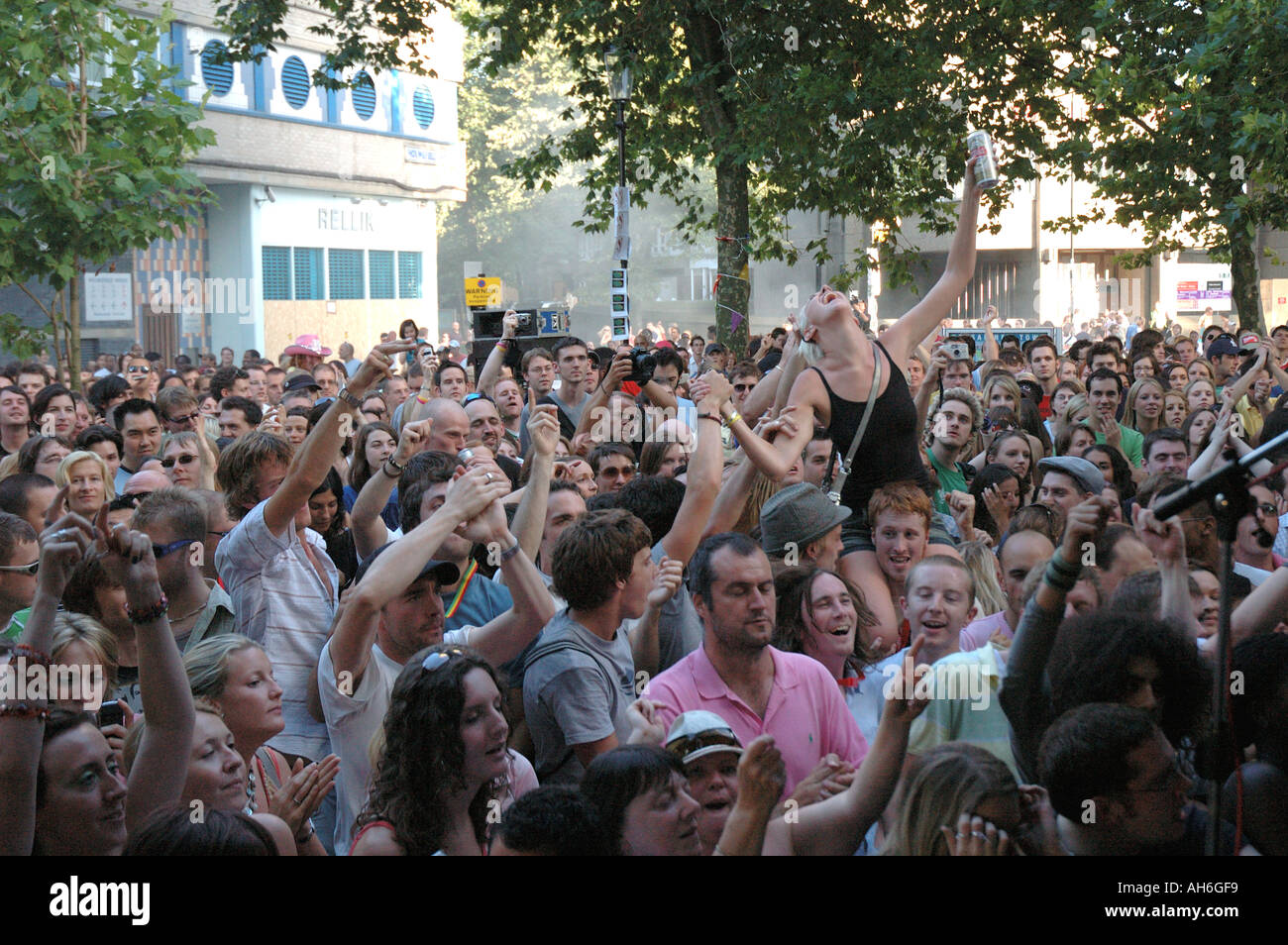 Crowd of young people dancing and cheering at street concert during ...