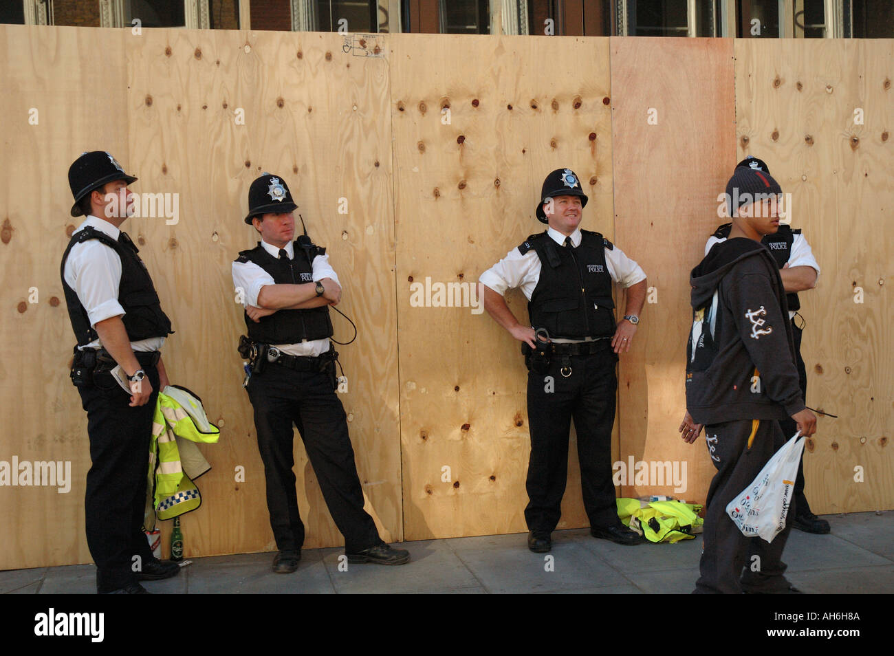 Four police officers on beat standing against wall in West London ...