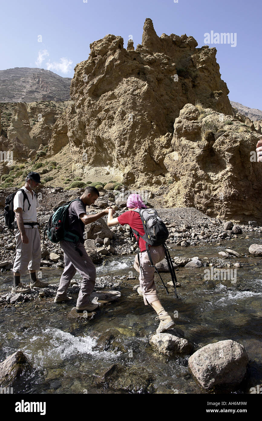 Hikers crossing a river family trekking in the High Atlas region ...