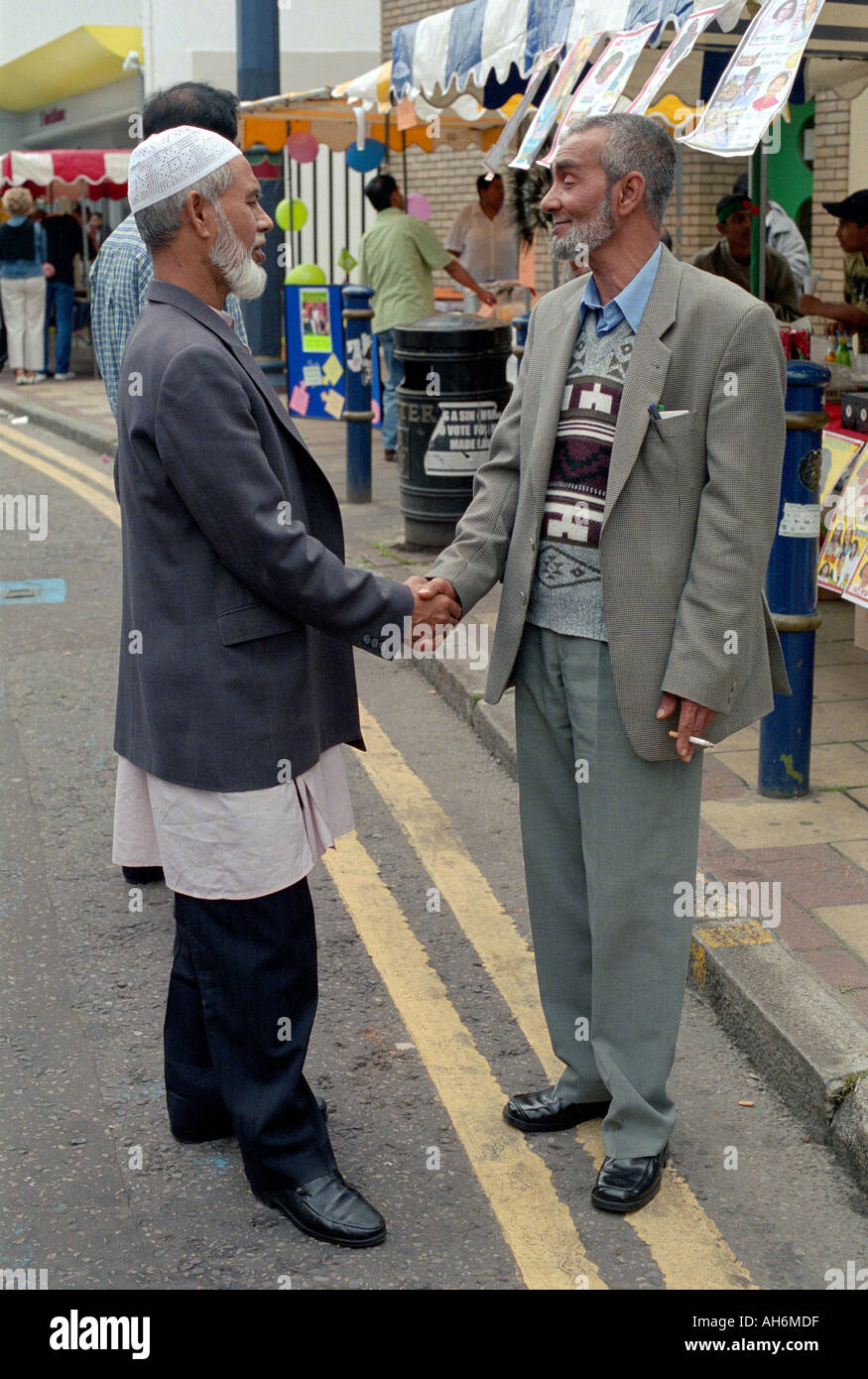 Two Asian men shaking hands greeting each other in Brink lane east ...