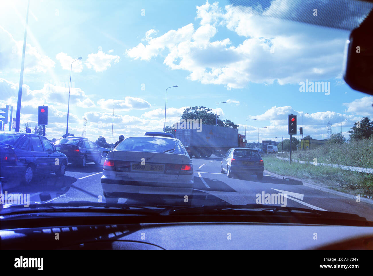 Cars on roadway with traffic lights seen through car window screen ...
