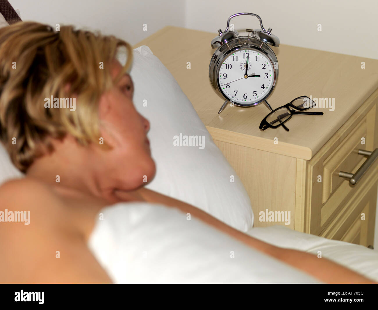 Woman Looking at Alarm Clock Model Released Stock Photo - Alamy