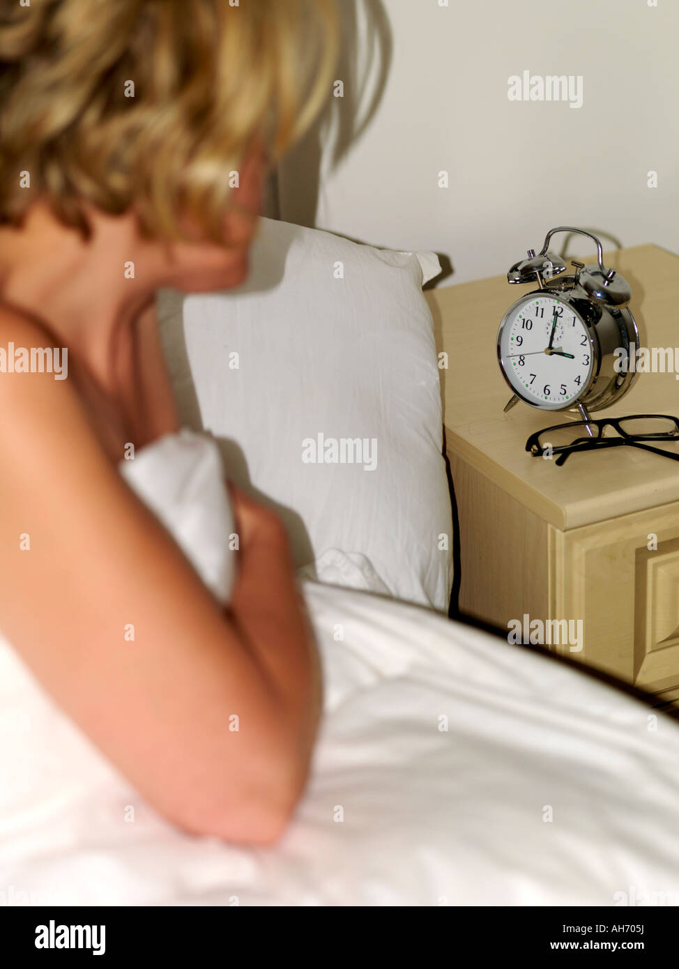 Woman Looking at Alarm Clock Model Released Stock Photo - Alamy