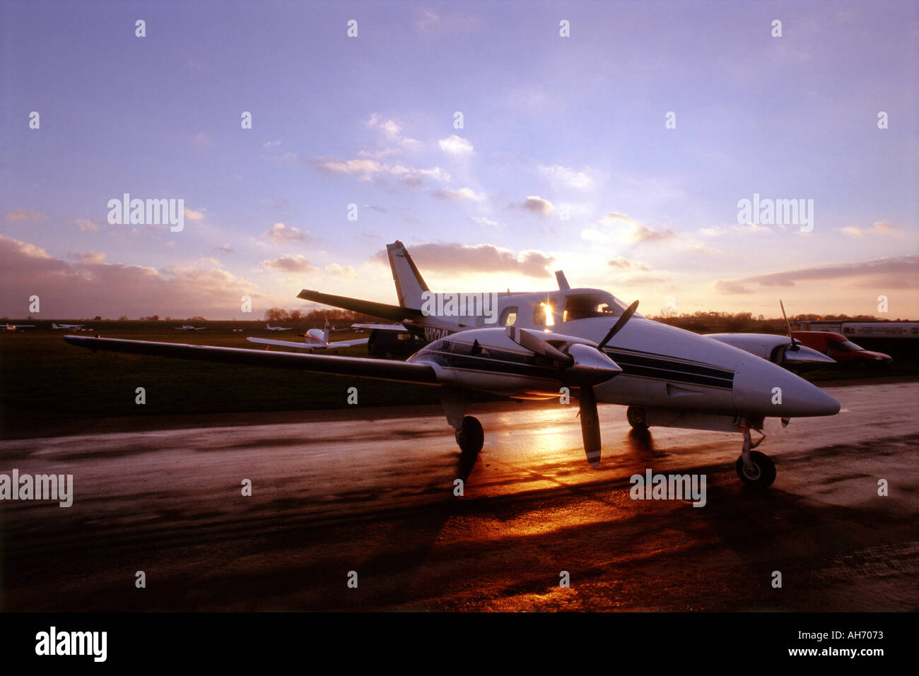 Small jet aircraft standing on tarmac at local airport with sunset ...