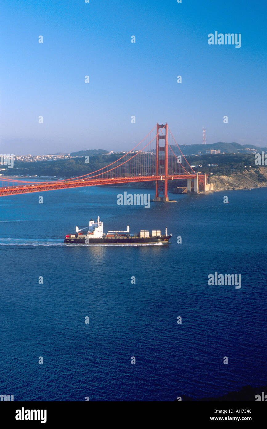 Container ship loaded with cargo passes beneath the Golden Gate Bridge ...