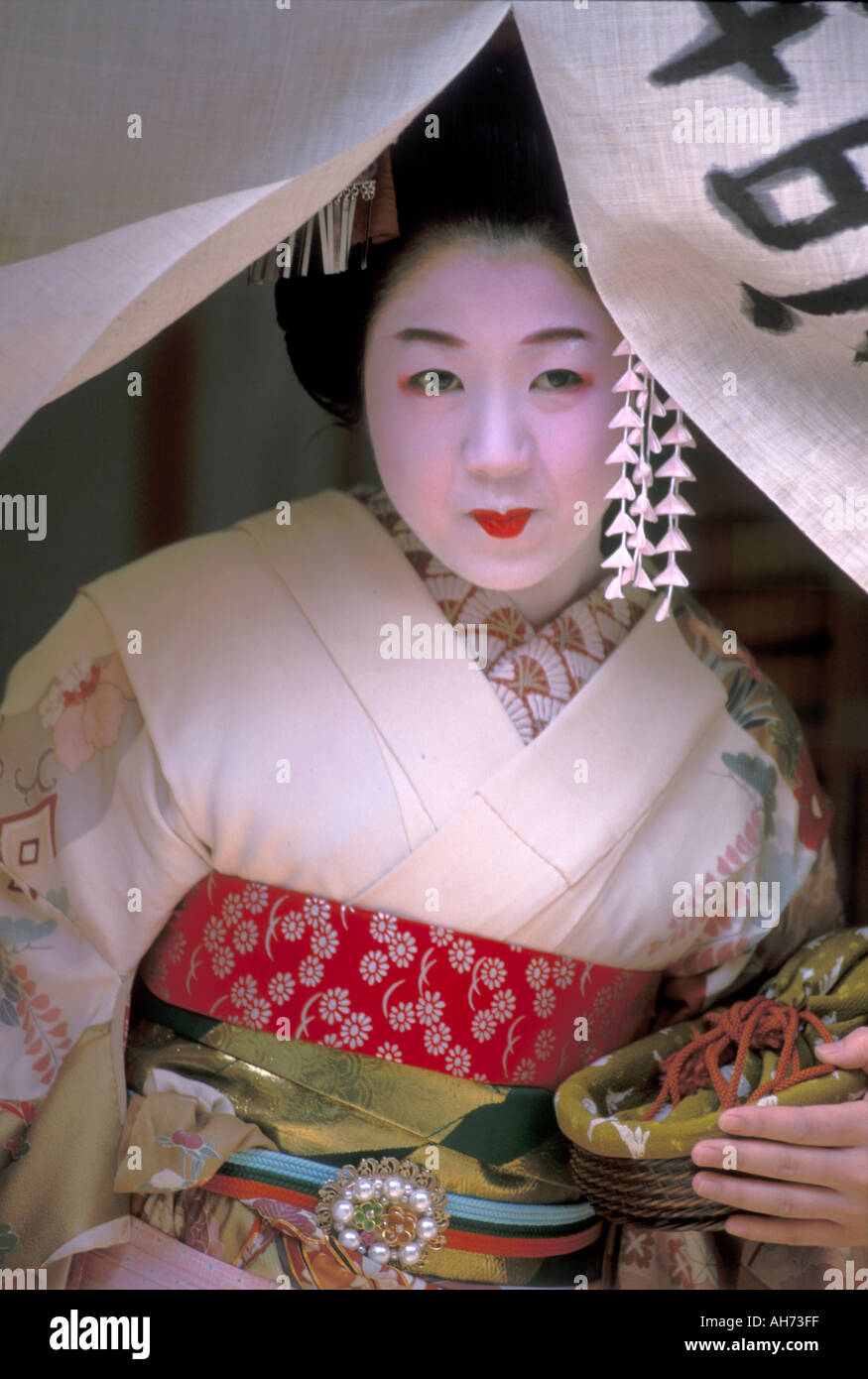 A tourist dressed as a maiko, or apprentice geisha in training, posing ...