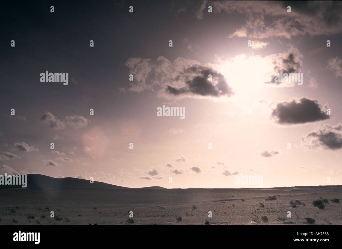 Sun setting over barron desert with signs of human activity Stock Photo ...