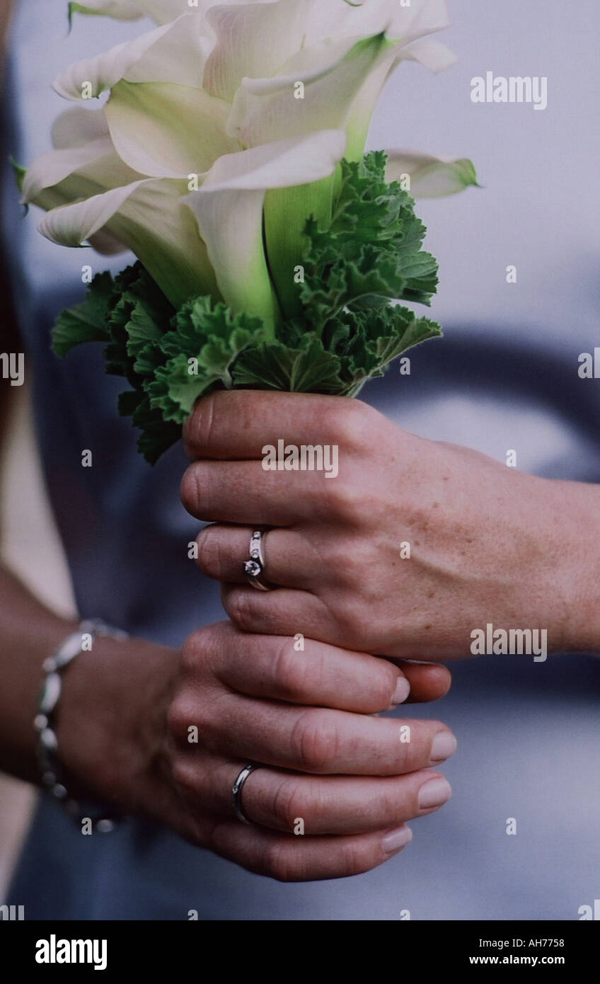 Hands holding cala lilly wedding flowers Stock Photo - Alamy