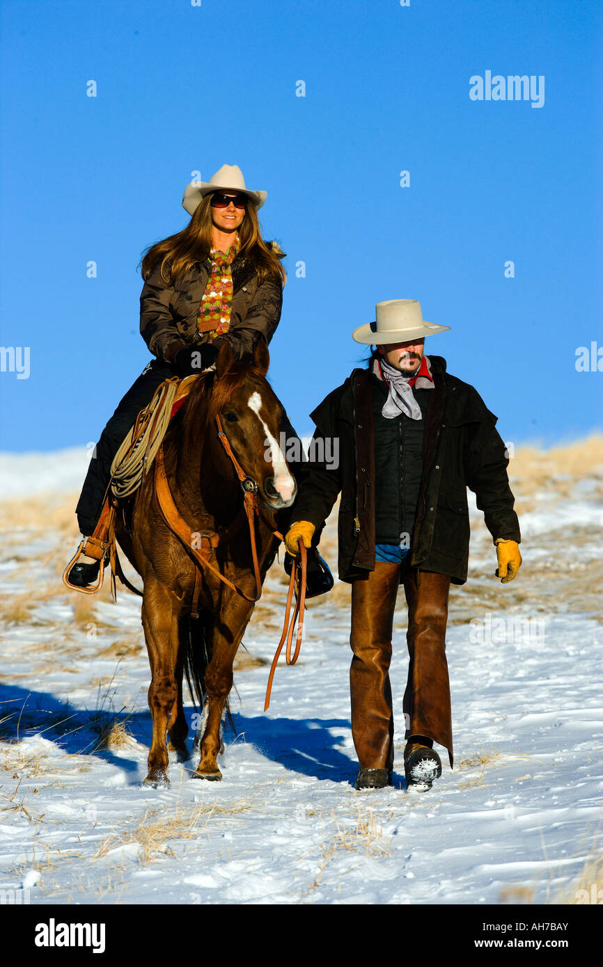 Mid adult woman riding a horse with a mid adult man guiding them Stock ...