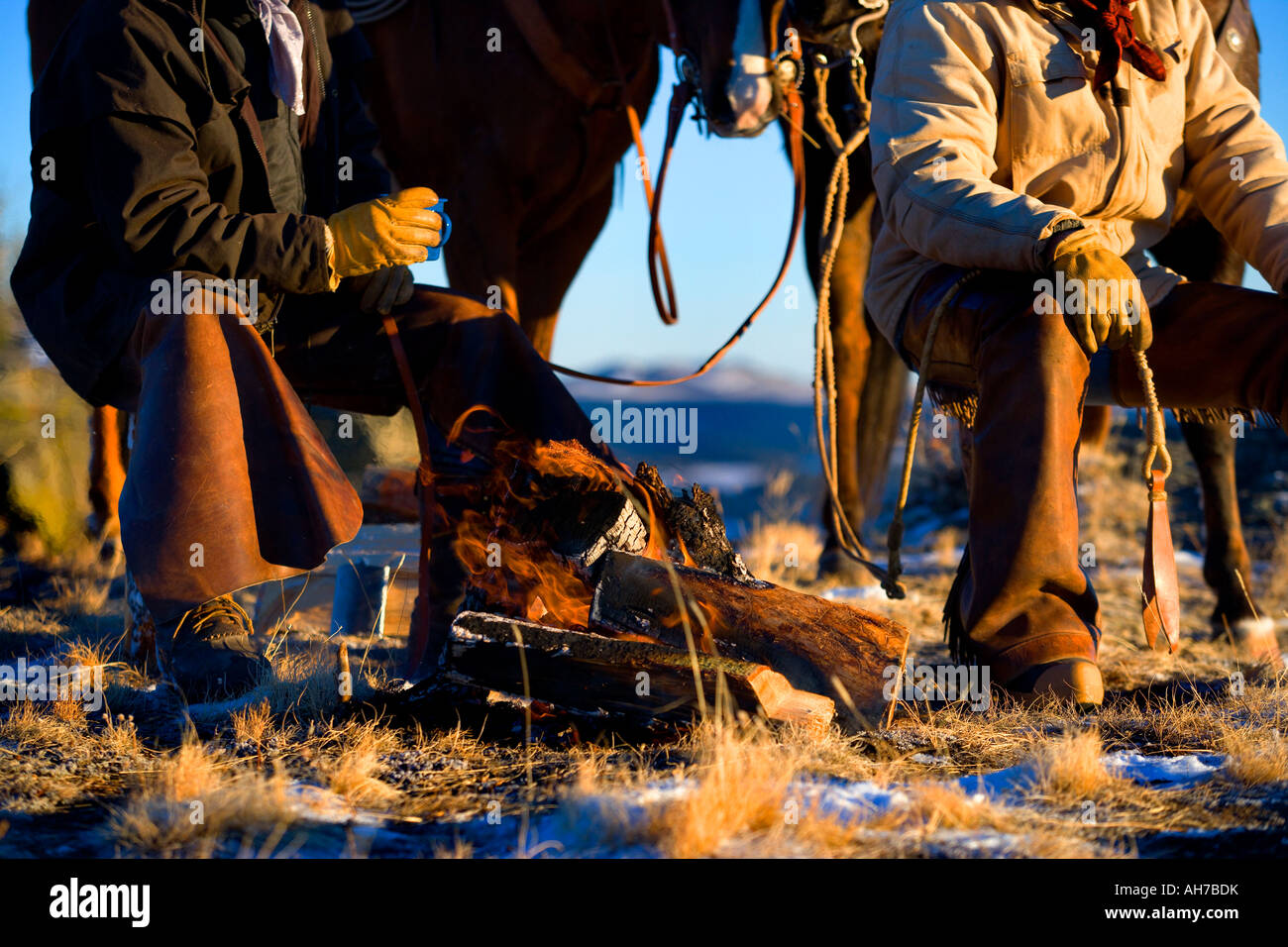 Low section view of two men sitting in front of a campfire Stock Photo ...