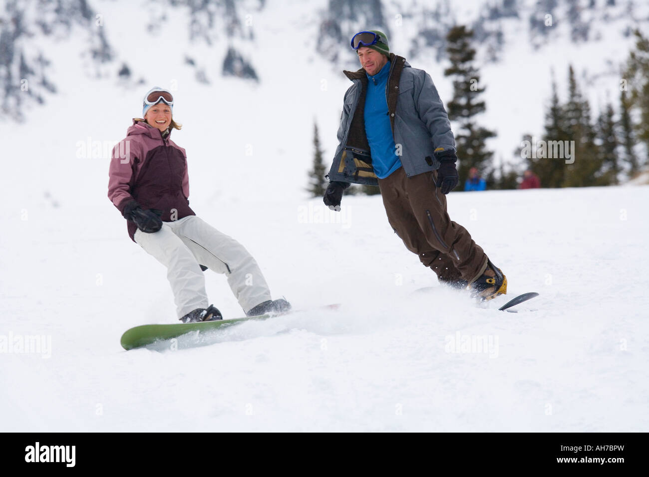 Mid adult couple snowboarding Stock Photo - Alamy