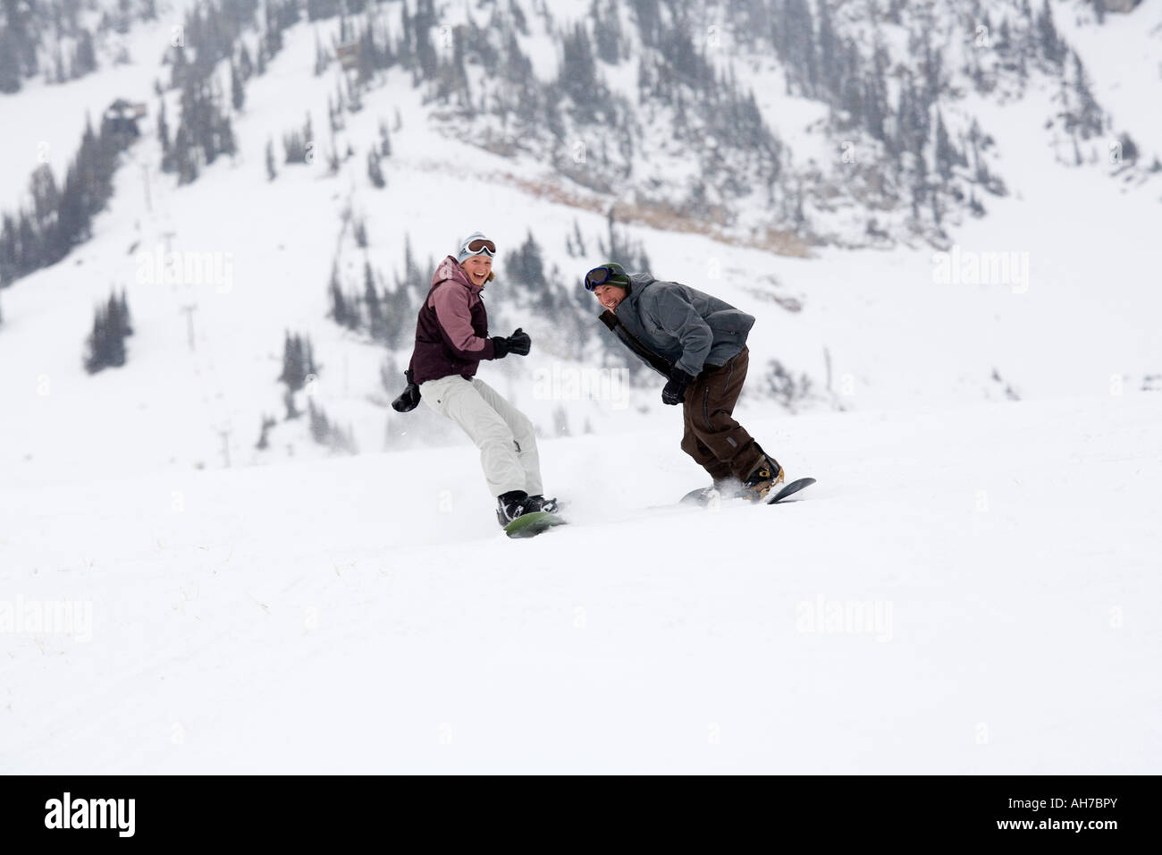 Mid adult couple snowboarding Stock Photo - Alamy
