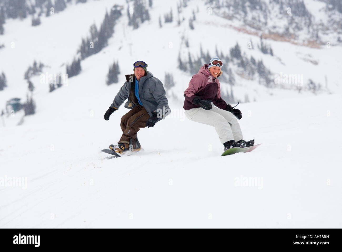 Mid adult couple snowboarding Stock Photo - Alamy
