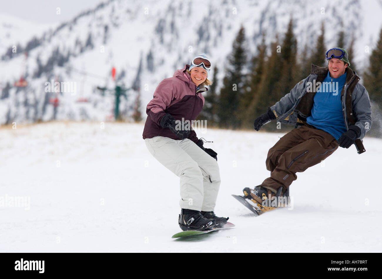 Mid adult couple snowboarding Stock Photo - Alamy