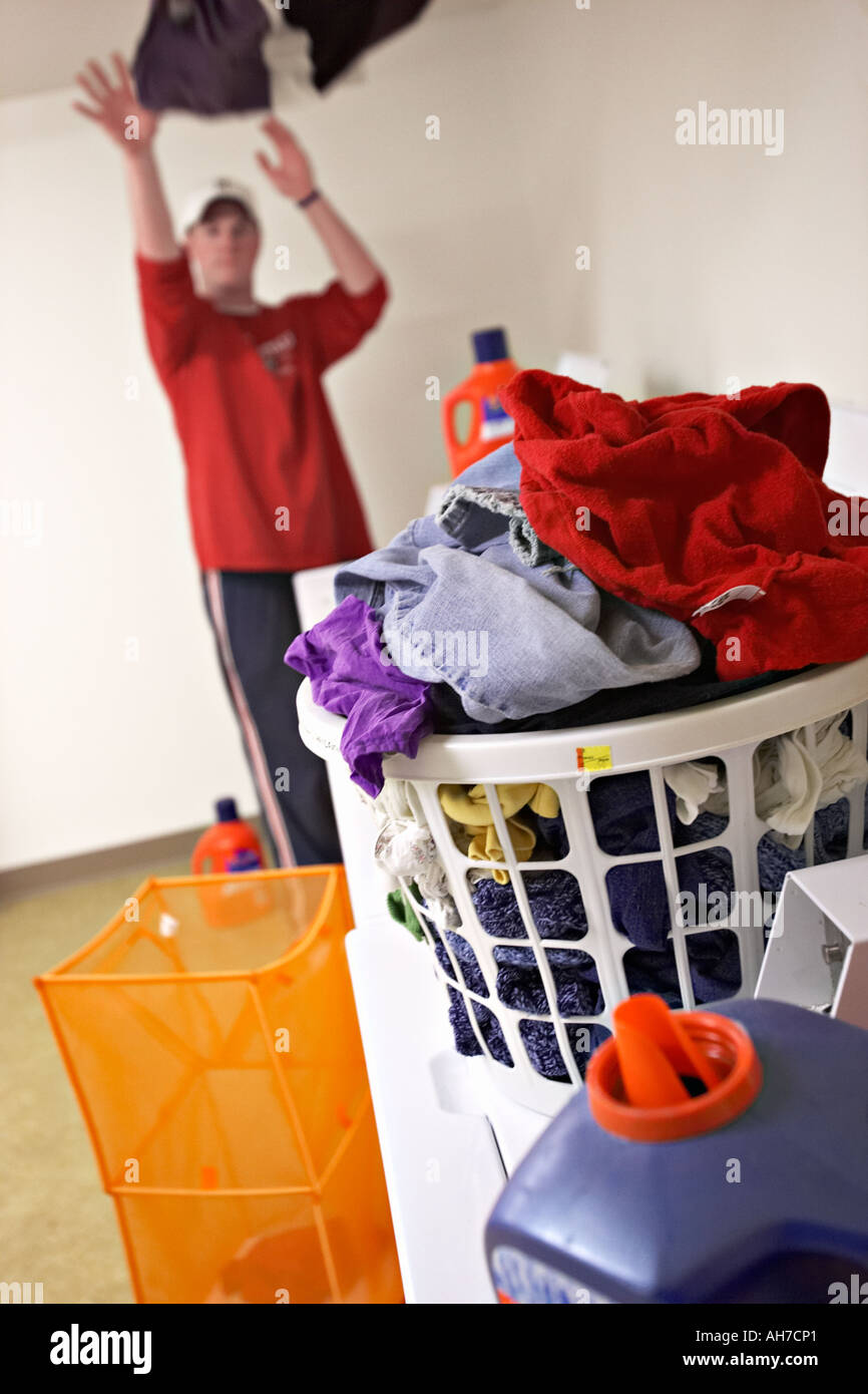 young man tossing laundry into laundry basket 12 29 years old 20 years ...