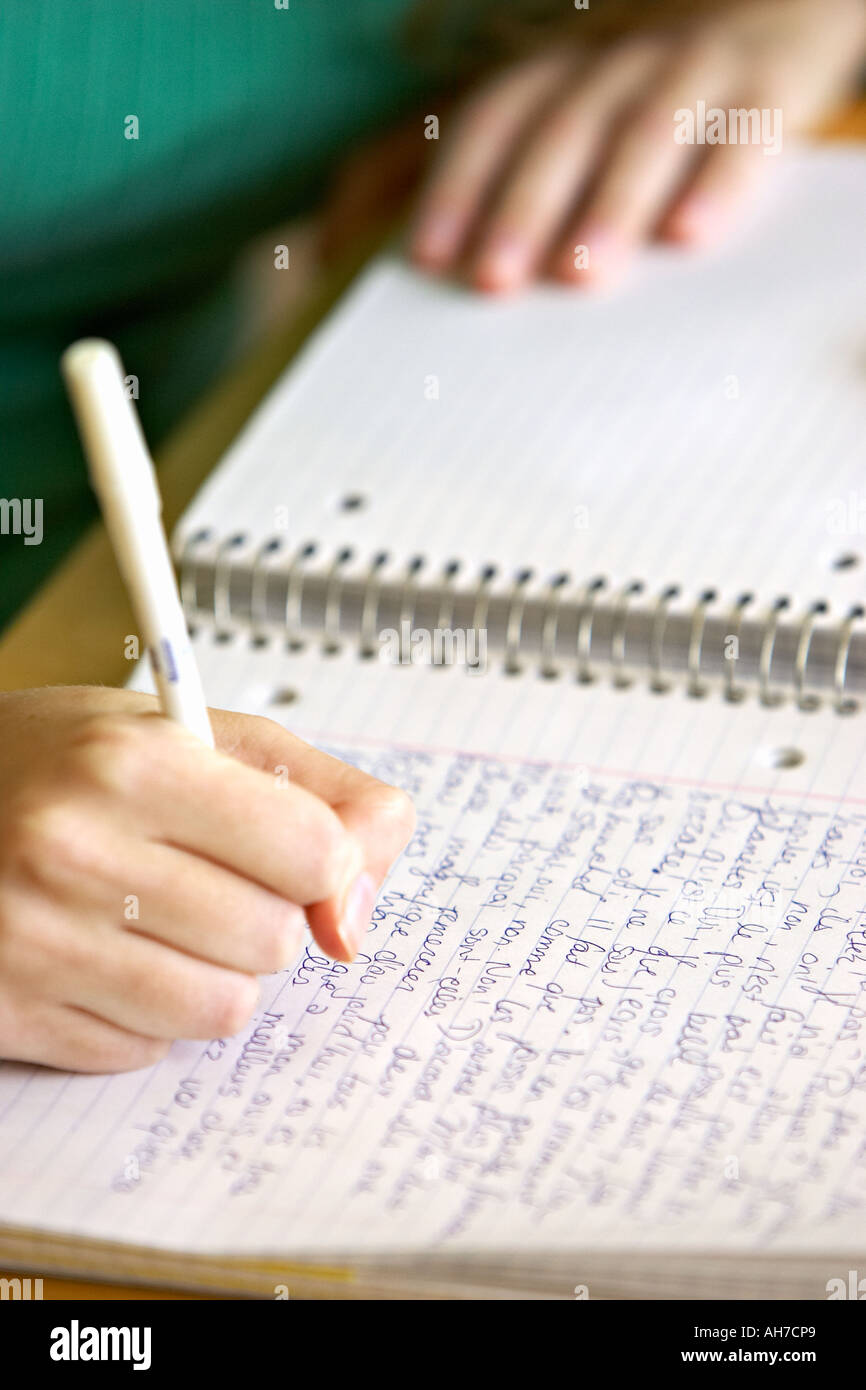 female student writing in book in French school equipment book books ...