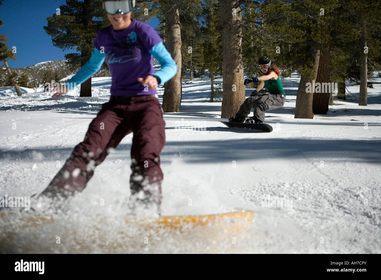 Two young women snowboarding Stock Photo - Alamy