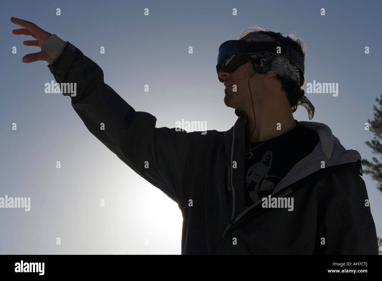 Young man with his arm raised wearing ski goggles Stock Photo - Alamy