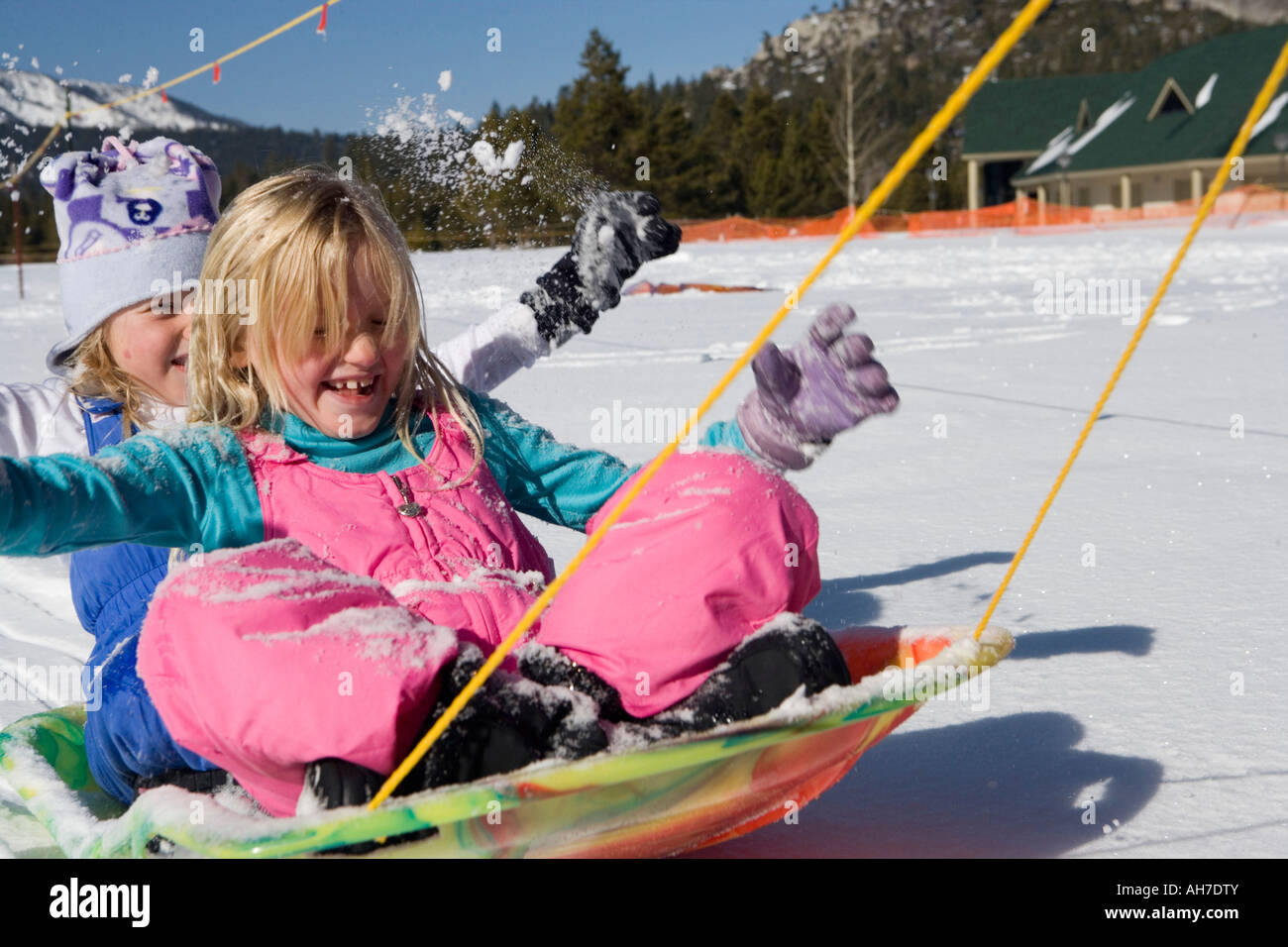 Two girls being pulled on a sled Stock Photo - Alamy