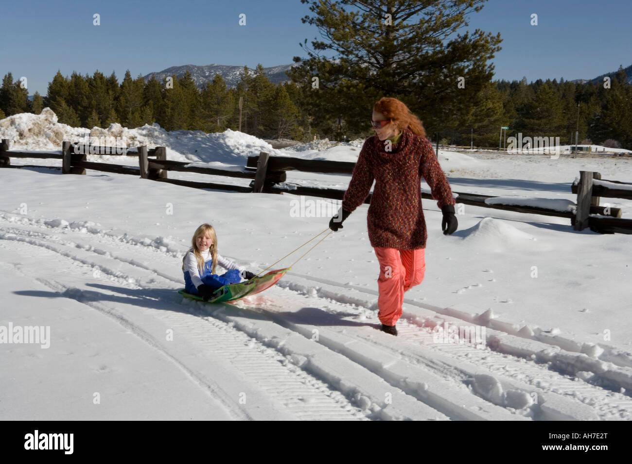 Mature woman pulling her daughter on a sled Stock Photo - Alamy