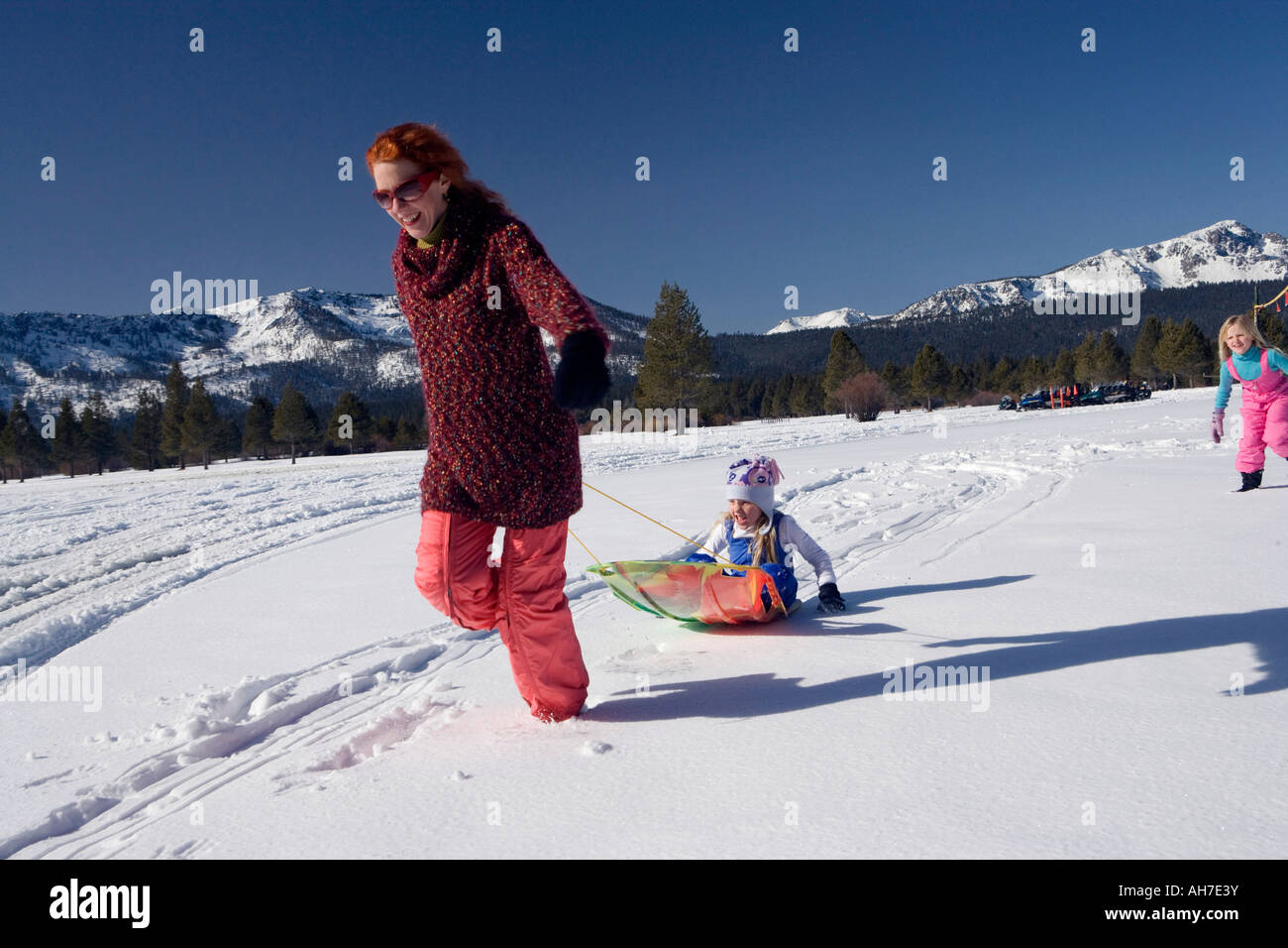 Mature woman pulling her daughter on a sled Stock Photo - Alamy